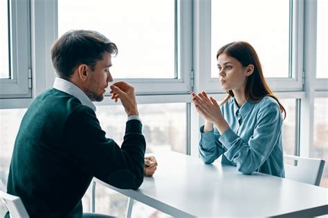 Premium Photo Man And A Woman Are Sitting At A Table Talking
