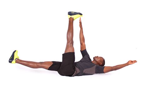 Fitness Man Demonstrating How To Perform Dead Bug Exercise High