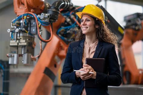 automation female engineer with tablet for programming robotic arm in