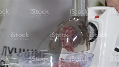 집에서 신선한 쇠고기에서 전기 고기 분쇄기에 다진 고기를 만들기 다진 고기 더미 신선한 다진 고기와 전기 광부 기계 전기 고기 분쇄기로 다진 쇠고기의 준비 가루로 빻은에