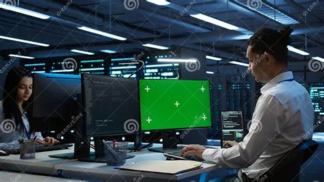 Employee Using Green Screen Devices In Server Farm Used For Automation