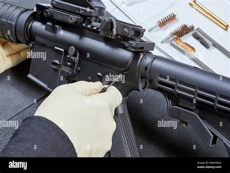 Gloved Hand Disassembling An Ar 15 Rifle In Preparation To Clean It
