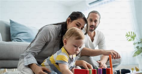 백인 행복 하 고 사랑하는 부모는 거실에서 아기 유아와 놀고 있습니다 매력적인 부부 어머니와 아버지는 집에서 어린 어린 유아 아들 아이와 함께 시간을 보냅니다 가정에서의