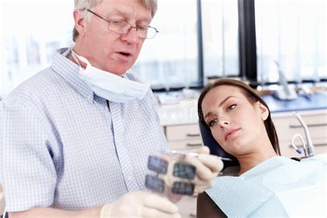 Doctor Showing X Ray To Female Patient Portrait Of Mature Doctor Showing Dental X Ray To His