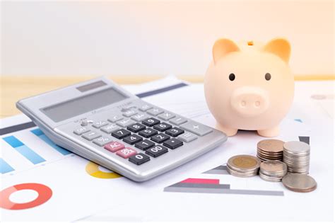 돼지 저금통과 계산기 옆에 있는 동전 더미에는 재무 계획의 개념이 있습니다 돈과 재정 개념을 절약합니다 성장 경제 비즈니스 및 투자에 대한 아이디어 은행 투자 걱정하는에