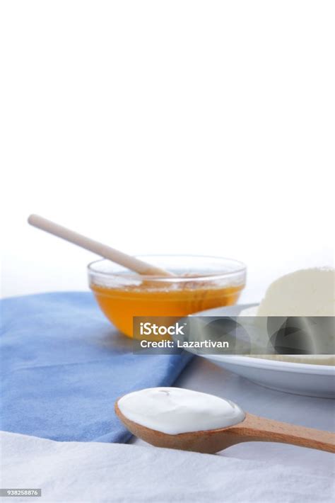 치즈 꿀 및 사 우 어 크림 흰색 접시 흰색 배경 사 우 어 크림 프랑스 아침 식사 블루 냅킨 나무 숟가락에 부드러운 치즈 Feta 유리 디자이너에 대 한 빈에 꿀 건강한