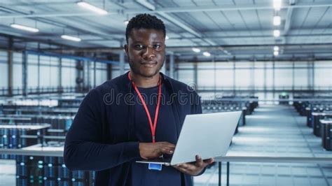 Portrait Of A Data Center Engineer Using Laptop Computer Server Room Specialist Facility With
