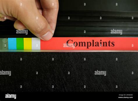 Hand Picking Complaints File Record In Black Binder Folder Customer Complaint Business And