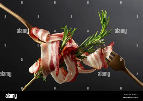 Dry Cured Pork Belly Bacon With Rosemary On A Black Background Sliced