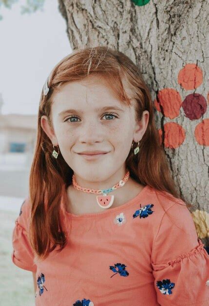 Premium Photo Portrait Of Smiling Girl Against Tree Trunk