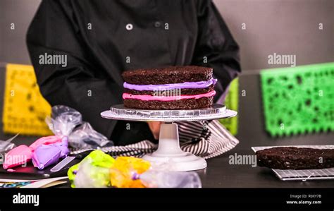 Step By Step Baker Assembling A Chocolate Cake With Bright Colorful