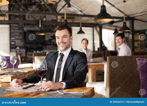 Стильный молодой человек сидя в ресторане Стоковое Фото изображение насчитывающей стрижка