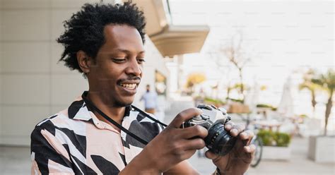 거리에서 야외를 걷는 동안 카메라로 사진을 찍는 아프리카 관광객의 초상화 관광 개념입니다 사진 Unsplash의 카메라와 사진 작가 이미지