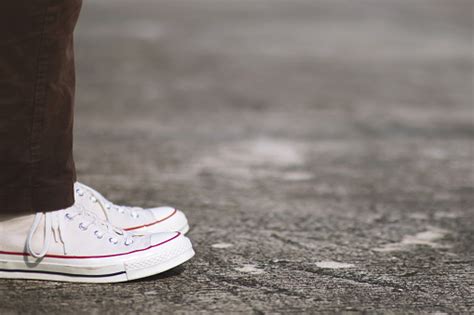 닫 다 다리 남자 서 있는도로 콘크리트 바닥 야외 입고 세련 된 청바지 바지 코 듀로이 브라운과 운동 화 신발 메시지를 쓰기 위해 빈 복사 공간을 비워 두십시오 거리에 대한