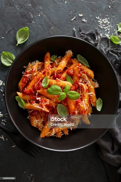 토마토 소스를 곁들인 페네 파스타 파마산 치즈 바질을 다크 백고운드에 얹어 먹습니다 건강한 식생활에 대한 스톡 사진 및 기타 이미지 건강한 식생활 검은색 녹색
