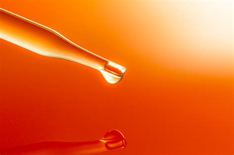 매크로 과학 실험 피펫 표면 화학 스포이드의 평면도 매크로 샷은 노란색 배경에 있는 세 가지 페트리 접시 중 하나에서 맑은 유체에 오일을 주입합니다 추상 스킨 케어 화장품