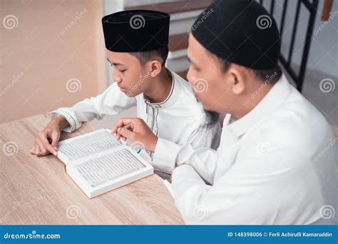 Pai Mu Ulmano Que Ensina A Seu Filho Como Ler O Quran Foto De Stock Imagem De Mubarak Lido