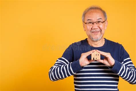 Portrait Asian Smiling Old Man With Glasses Holding Small House Model