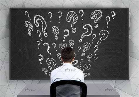 عکس با کیفیت مرد نشسته پشت میز در مقابل تخته سیاه و علامت های سوال روی آن عکس با کیفیت و