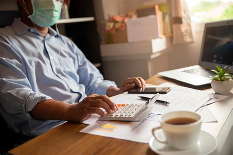 예산 계획 개념 회계사 착용 마스크는 회사의 연간 세금을 계산하고 있습니다 캘린더 2020 및 미국 법에 따라 소득이 있는 사람들을 위한 개인 소득세 양식이 홈 데스크에