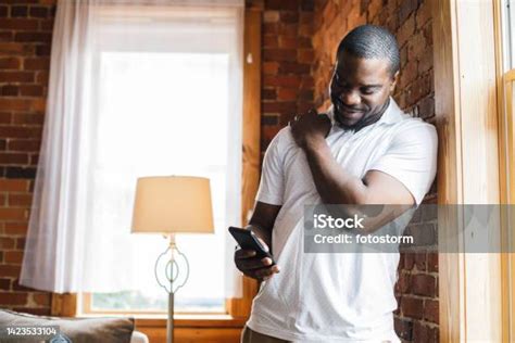 벽돌 벽에 기대어 스마트 폰을 통해 문자 메시지에 응답하는 쾌활한 남자 손을 어깨에 두기에 대한 스톡 사진 및 기타 이미지 손을 어깨에 두기 40 44세 거실