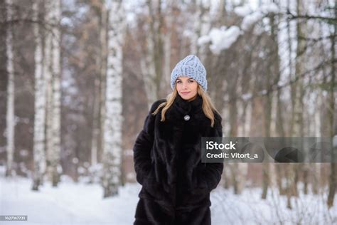 푸른 모자를 쓴 공정한 머리 소녀 눈 덮인 겨울 자작 나무 숲을 배경으로 검은 모피 코트 30 34세에 대한 스톡 사진 및 기타 이미지 30 34세 검은색 겨울