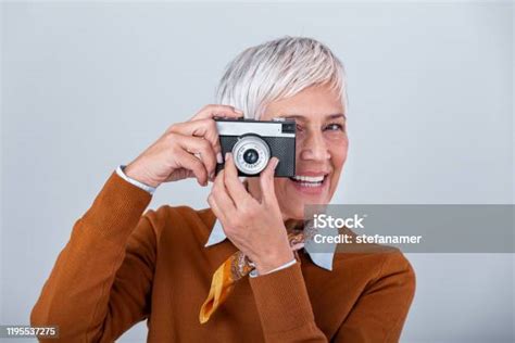 성숙한 여성 사진 작가 오래 된 복고풍 카메라와 함께 사진을 찍고 전문 사진 작가가 사진 촬영을하고 있습니다 동작 활동에 대한 스톡 사진 및 기타 이미지 Istock