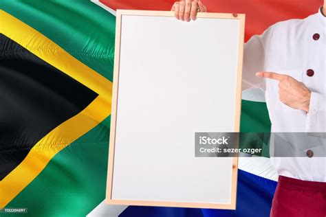 남아프리카 공화국 국기 배경에 빈 화이트 보드 메뉴를 들고 요리사 텍스트에 대 한 균일 한 포인팅 공간을 착용 요리 고급 요리에 대한 스톡 사진 및 기타 이미지 Istock