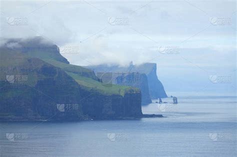 空中 飞越平静的海洋 向法罗群岛风景如画的海滨壮观的小岛的黑色悬崖飞行多云的白天 斯堪的纳维