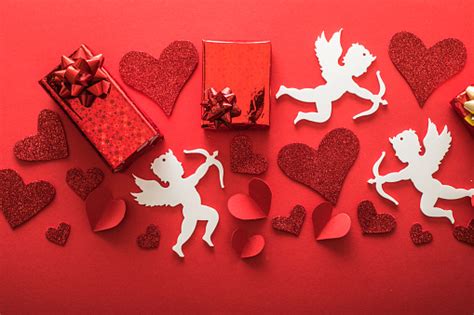 하트 선물 행복한 발렌타인 데이 배너 종이 아트 스타일이 있는 플라잉 큐피드 실루엣 빨간 종이에 아무르 2월에 대한 스톡 사진