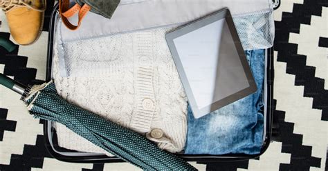 젊은 여성 관광객은 겨울과 가을의 따뜻한 물건을 큰 여행 가방에 포장합니다 여행 준비 개념입니다 위 또는 평면도에서 볼 수 있습니다 사진 Unsplash의 가방 이미지