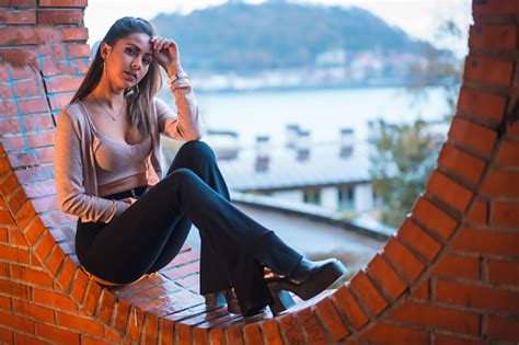 백인 갈색 머리 모델은 아름다운 포니 테일과 분홍색 스웨터와 배경에 도시와 앉아 스트리트 스타일 패션 25 29세에 대한 스톡 사진 및 기타 이미지 Istock