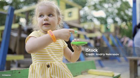 귀여운 어린 소녀가 놀이터의 샌드 박스에서 놀고 있습니다 도시 공원의 놀이터에서 놀고있는 어린이 소녀 2 3 살에 대한 스톡