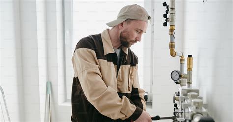 욕실이나 화장실에서 수리 작업 중 수공구를 사용하는 젊은 배관공 사진 Unsplash의 보호 작업복 이미지