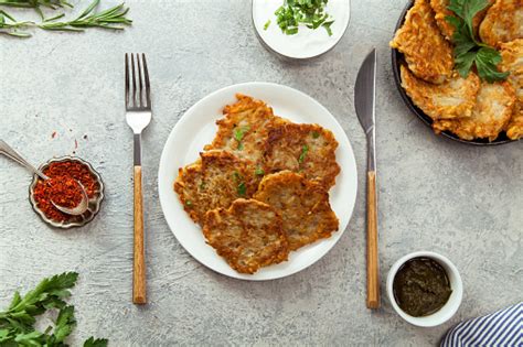 감자 Latkes 전통적인 유태인 팬케이크 사 우 어 크림 파 슬 리 마른 붉은 고추 부스러기와 민트 소스 파란 꽃 배경 흰색 냅킨입니다 Hannukah 축 하 요리