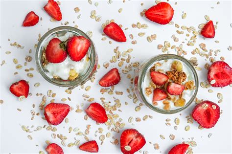 건강한 아침 식사 오트밀 그라놀라와 그리스 요구르트와 견과류 딸기 뮤즐리가 가벼운 배경에 항아리에 담을 수 있습니다 비건 채식주의 자 및 체중 감량 다이어트 개념 해독 메뉴