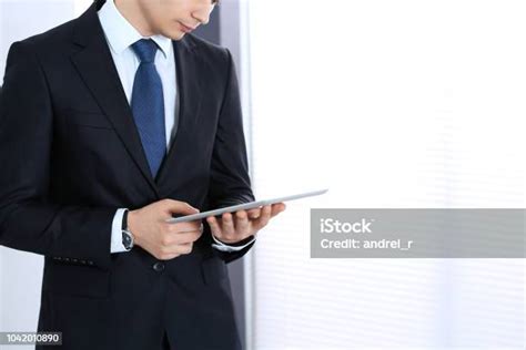 사무실에서 똑바로 서 있는 동안 태블릿 컴퓨터를 사용 하 여 젊은 사업가 비즈니스 개념 경영자에 대한 스톡 사진 및 기타 이미지 경영자 그래픽 사용자 인터페이스