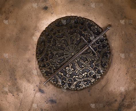 金色背景上的中世纪盾牌和剑