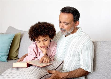 Avô E Neto Lendo Livro Sentados Juntos Em Casa Foto Premium