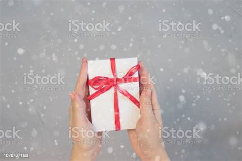 여자 손 다 색된 색종이와 파스텔 핑크 배경에 붉은 활과 선물 상자를 들고 평면 위치 스타일입니다 공휴일에 대한 스톡 사진 및