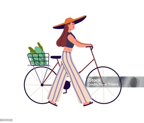 젊은 여자는 바구니와 함께 숙녀 자전거에 야채를 운반합니다 여름 모자를 쓴 소녀는 자전거를 타고 걷는 동안 자전거 근처에갑니다