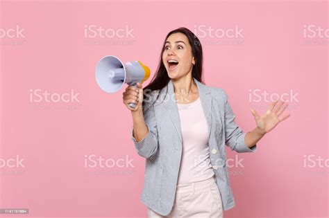 옆으로 보이는 줄무늬 재킷에 쾌활 한 젊은 여자의 초상화 스튜디오에서 분홍색 파스텔 벽 배경에 고립 된 확성기에서 비명 사람들은 진심으로 감정 라이프 스타일 개념입니다 복사