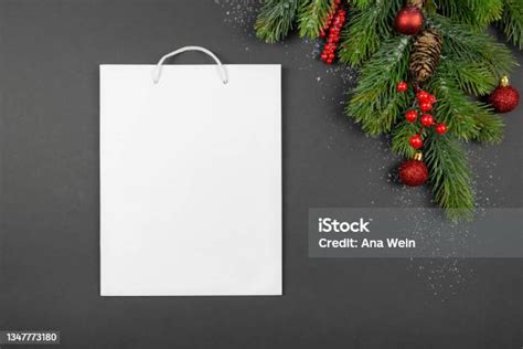 흰색 선물 쇼핑 가방 모형 빨간 공 장식 열매와 붉은 배경에 전나무 나무 가지와 크리스마스 축제 플랫 평지 구성 맨 위 보기입니다 공간을 복사합니다 쇼핑백에 대한 스톡 사진