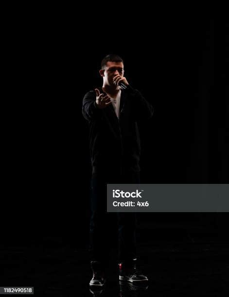 전체 길이한 사람1 인정면 2029 세 성인 잘 생긴 사람들 백인 남성젊은 남자 가수음악가 서노래행복 하 고 마이크를 들고 검은 배경 앞에서 춤 20 24세에 대한 스톡