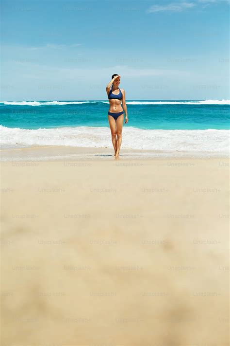 해변에서 비키니를 입은 여자 섹시한 행복한 소녀 패션 스포츠 수영복을 입은 건강한 선탠 멀리 바라보며 럭셔리 리조트에서 여름 휴가를 보내고 있습니다 여름을 즐기는