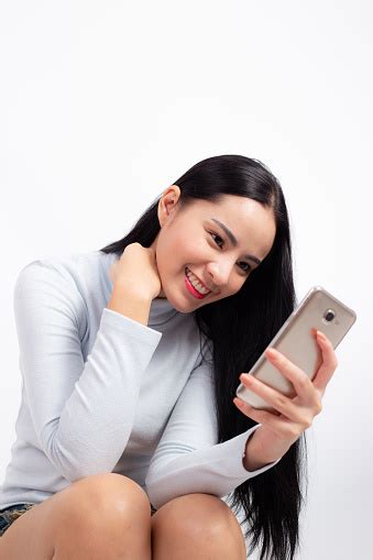 고립 된 흰색 배경에 서 스마트 폰을 사용하여 예쁜 젊은 아시아 여성 그녀는 휴대 전화로 문자 메시지를 합니다 관능에 대한 스톡 사진 및 기타 이미지 Istock