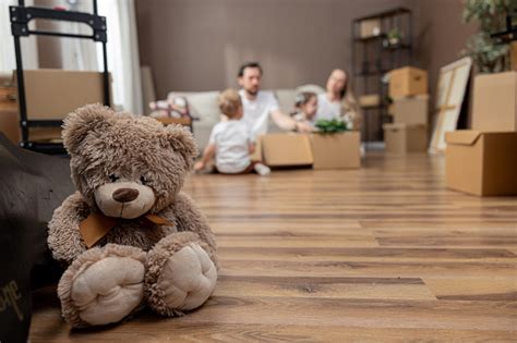 결혼 한 부부는 이사하는 과정에 있으며 새 아파트에 앉아 천천히 자녀와 함께 소지품 상자를 풀고 이야기하고 웃고 장소 변화를 즐기고 토론합니다 부동산에 대한 스톡 사진 및