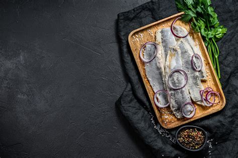 파슬리와 붉은 양파와 소금에 절인 청어의 필레 검은 소박한 배경에 맨 위 보기 텍스트를 위한 공간 건강한 식생활에 대한 스톡