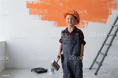 바지를 입은 소년이 손에 페인트브러시를 들고 방에 서 있다 홈 리노베이션 컨셉 Diy에 대한 스톡 사진 및 기타 이미지 Diy 가정의 방 개선 Istock