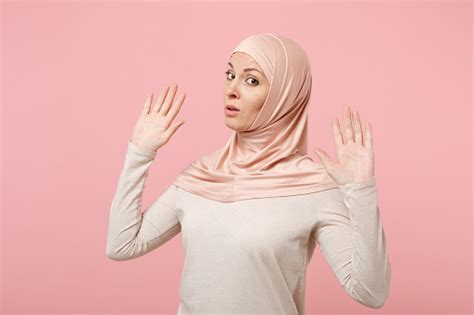 분홍색 배경 스튜디오 초상화에 고립 포즈 히잡 가벼운 옷을 입고 방해 아라비아 무슬림 여성 사람들은 종교 이슬람 라이프 스타일 개념 복사 공간을 모의합니다 손을 들어